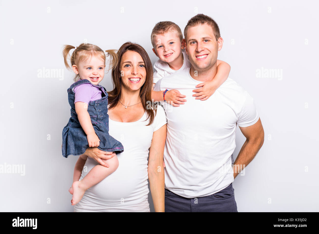 A Happy family with two kids on studio white Stock Photo - Alamy