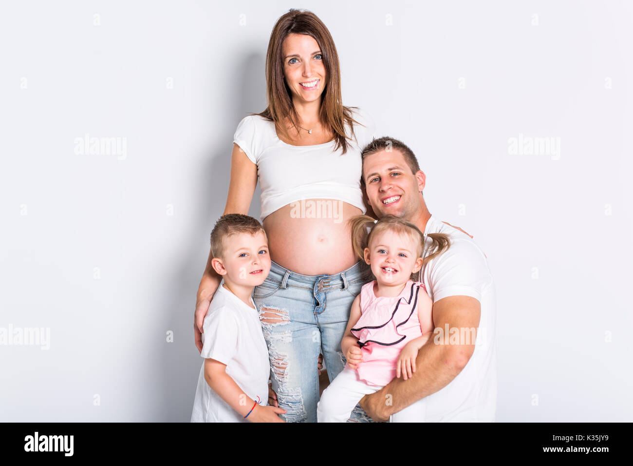 A Happy family with two kids on studio white Stock Photo - Alamy