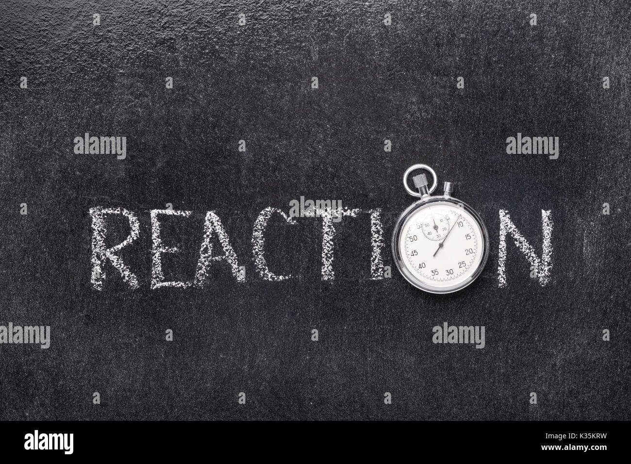 reaction word handwritten on chalkboard with vintage precise stopwatch ...