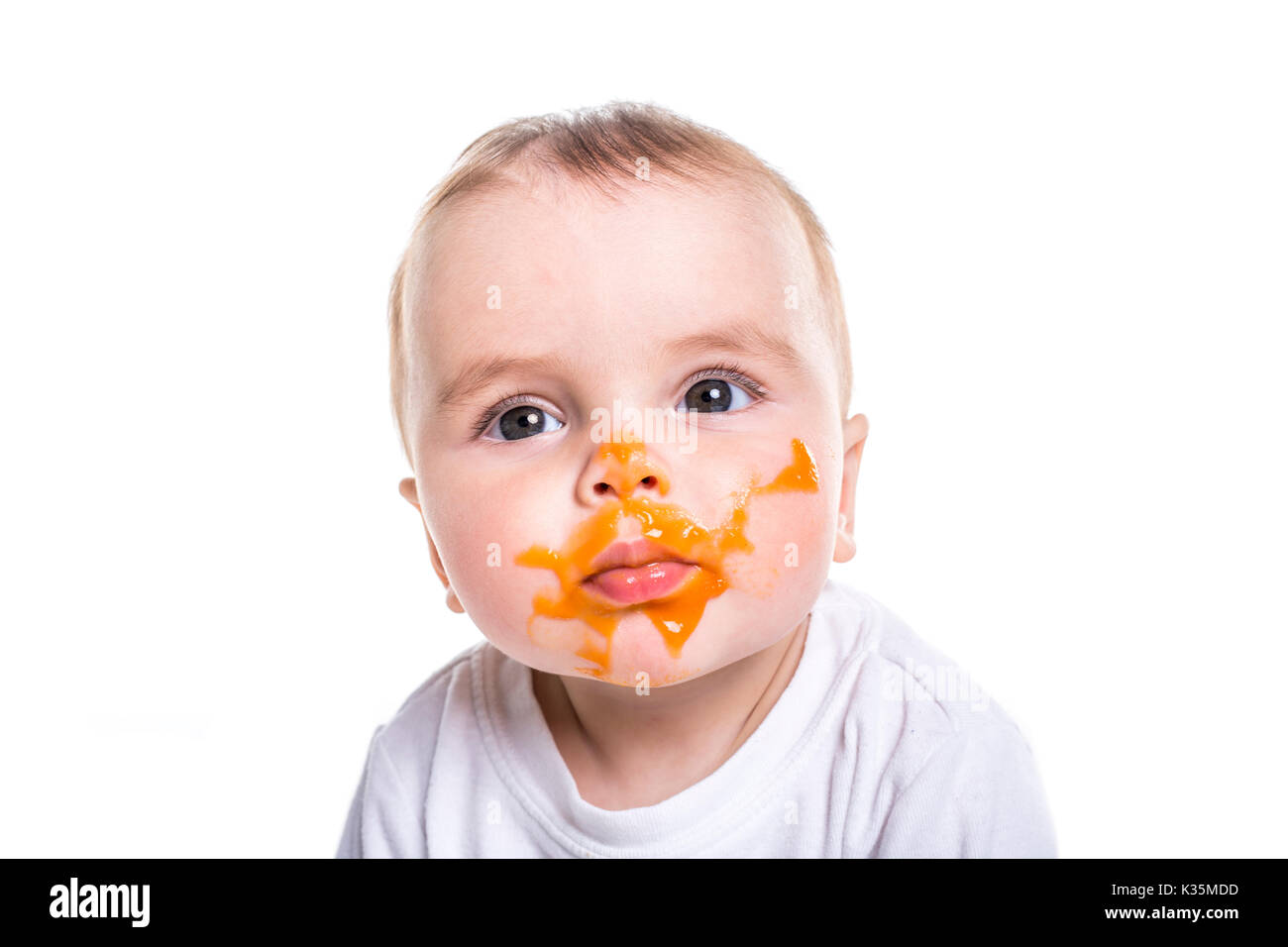 Adorable baby girl making a mess while feeding Stock Photo - Alamy