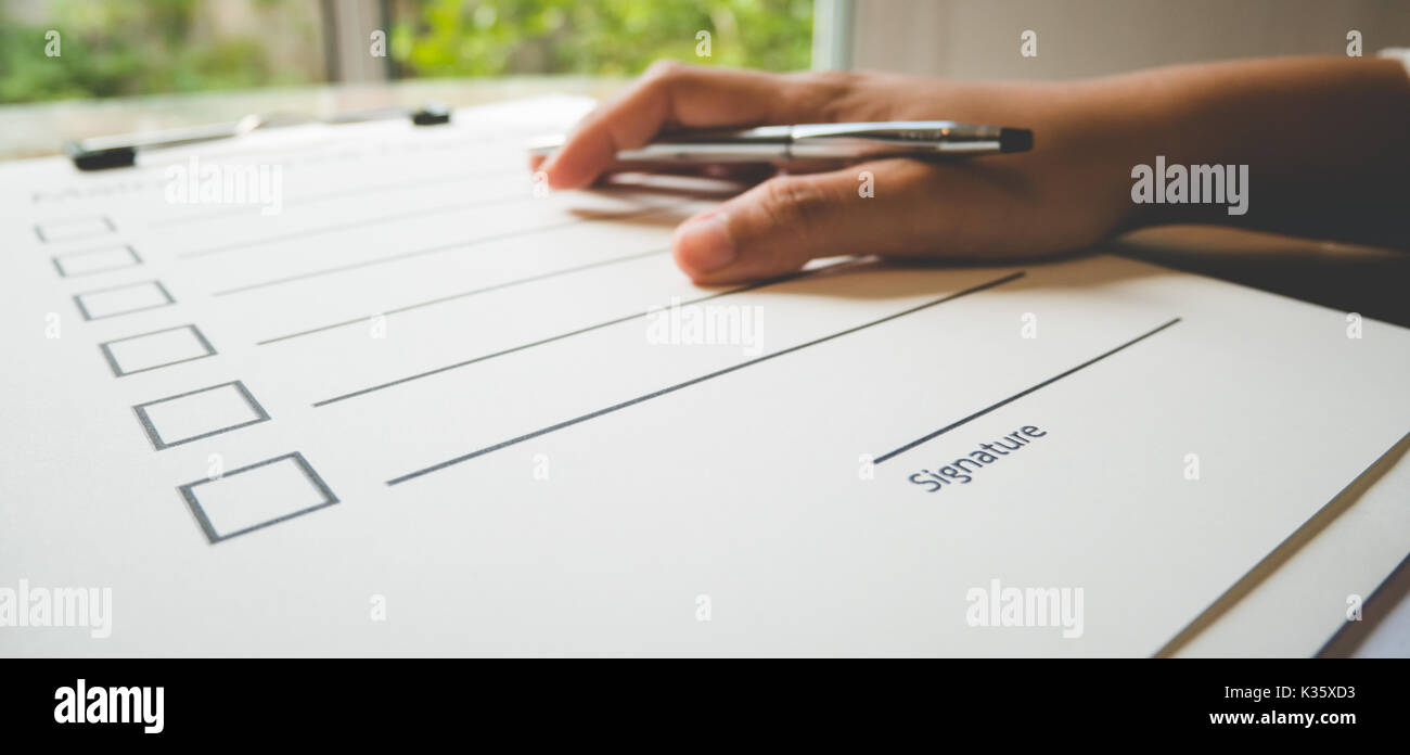 Close- up hand with pen on maintenance check paper and the format for ...