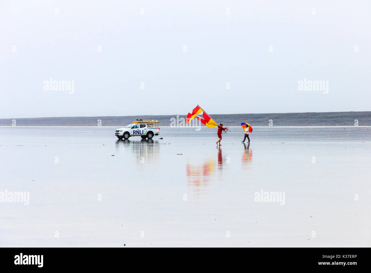 Rnli lifeguard carrying the red and yellow flags hi-res stock ...