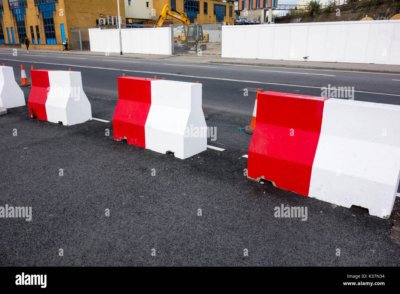 Red and white concrete blocks on a road junction blocking a street ...