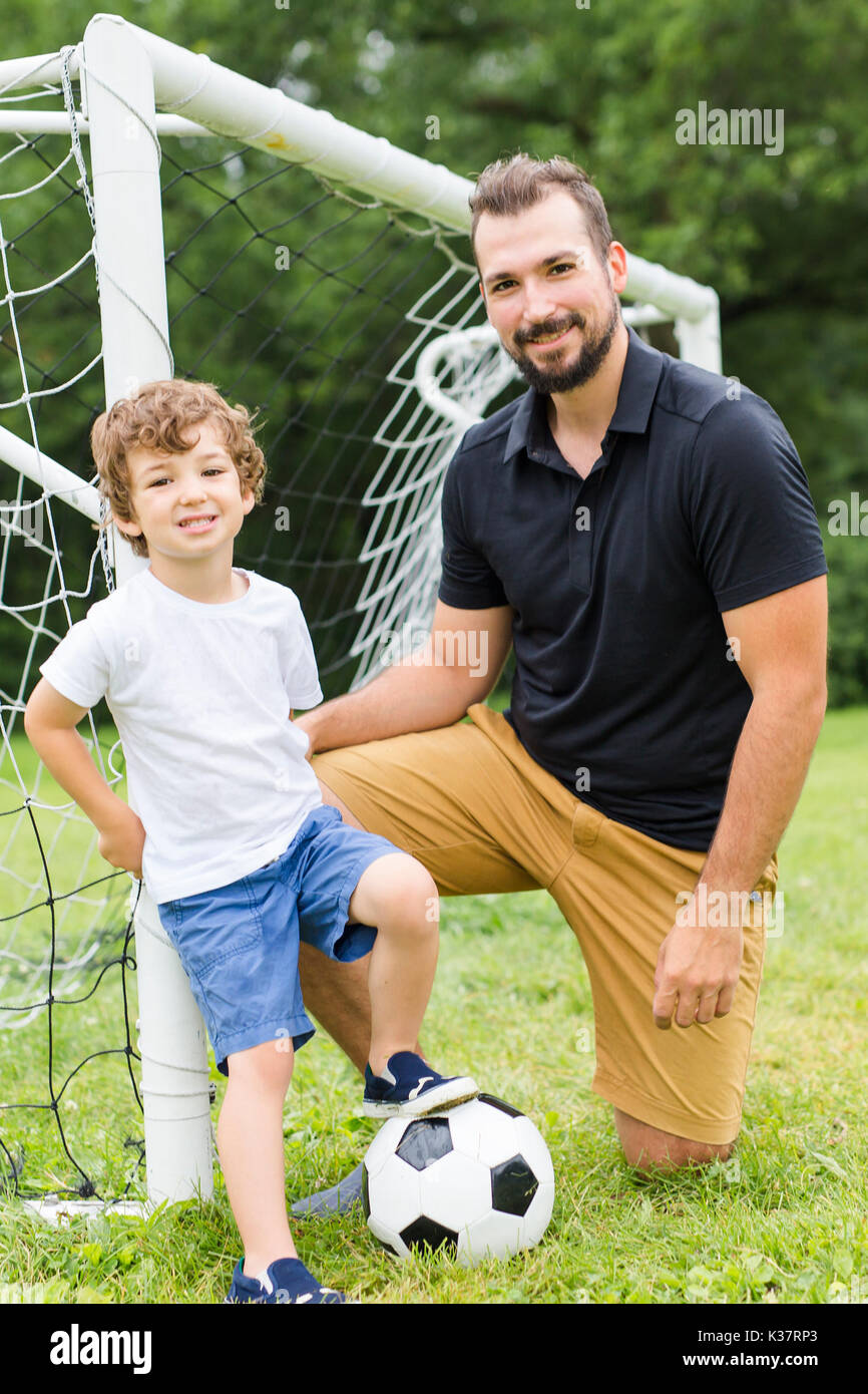 father with son playing football on football pitch Stock Photo - Alamy