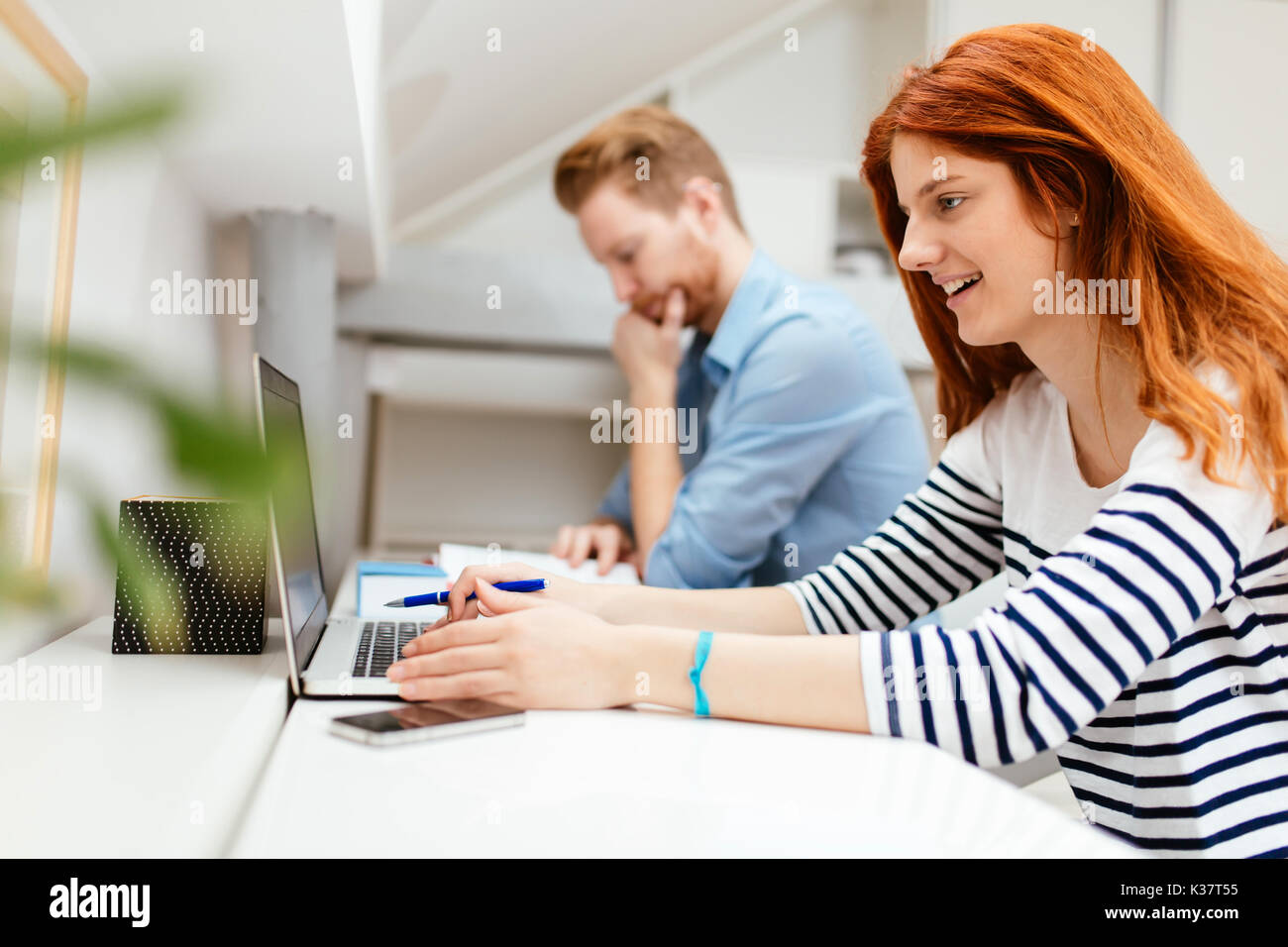 Colleagues working studying in white office Stock Photo - Alamy