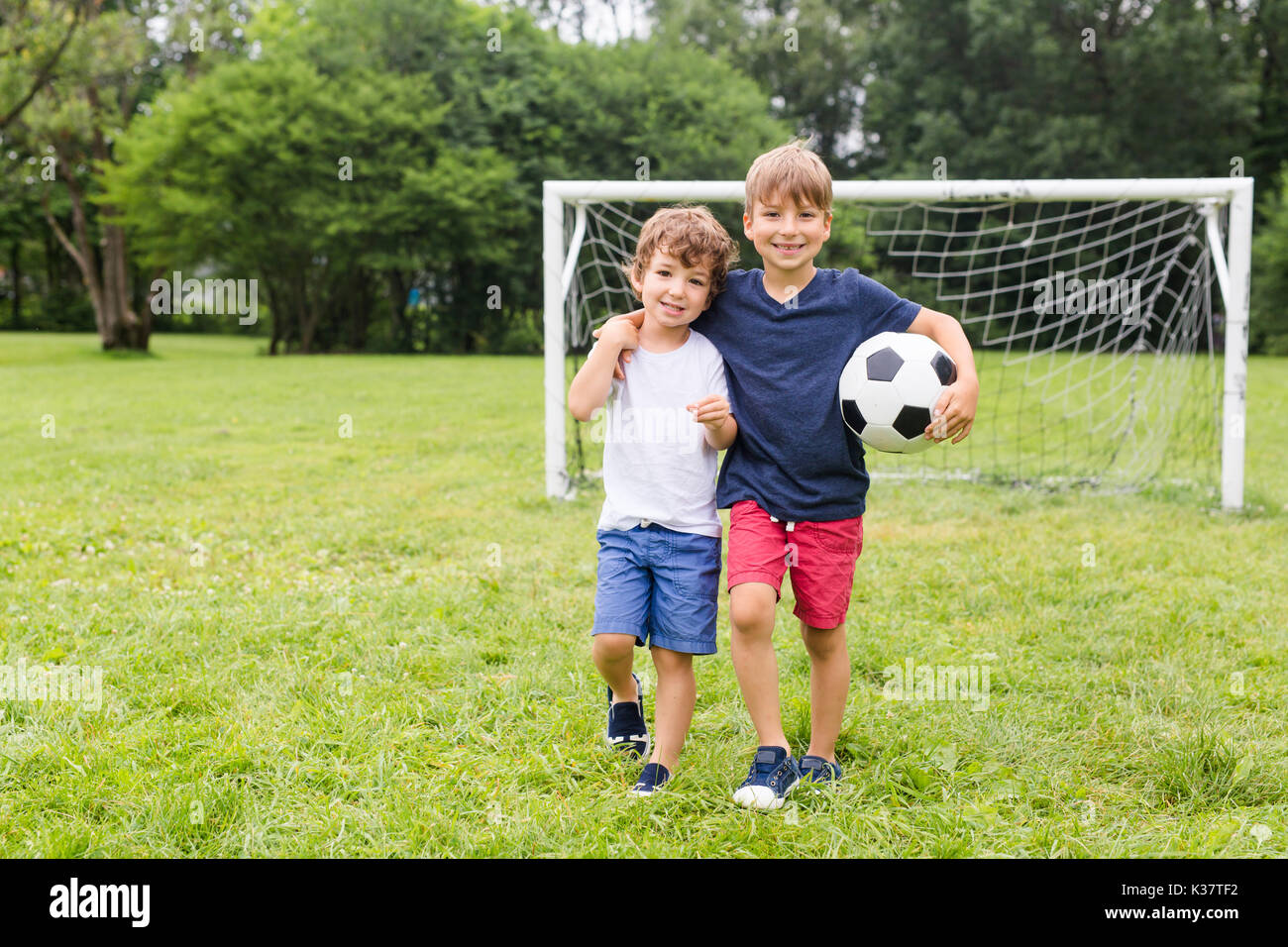 Two brothers having fun playing with ball Stock Photo - Alamy