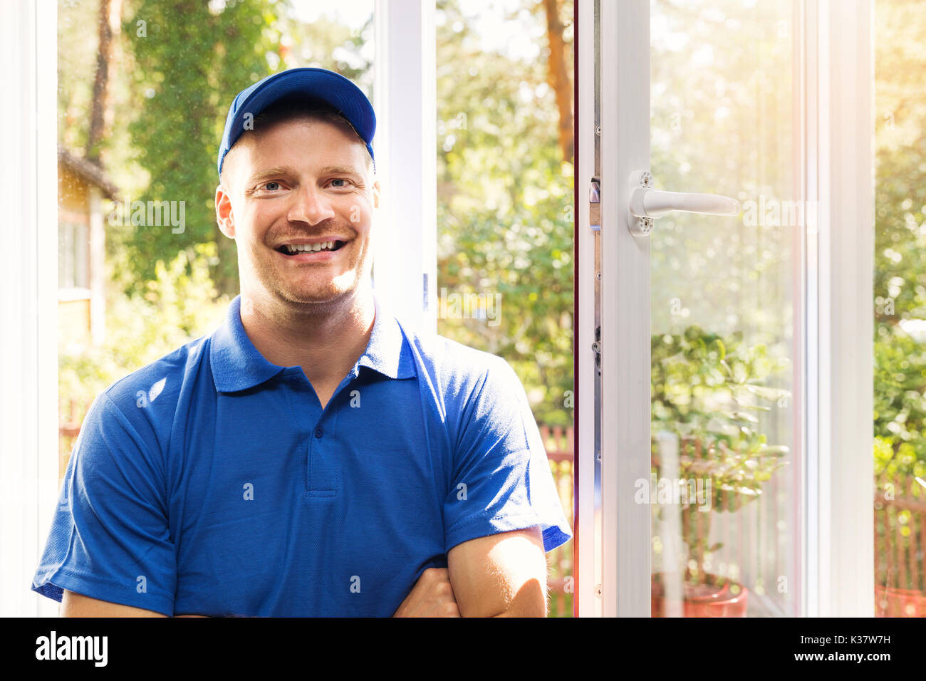 smiling window installer in blue uniform standing in the room Stock ...