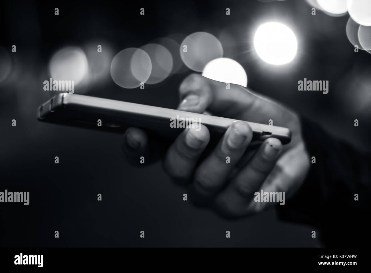 A hand holding and using digital smart phone at night Stock Photo - Alamy