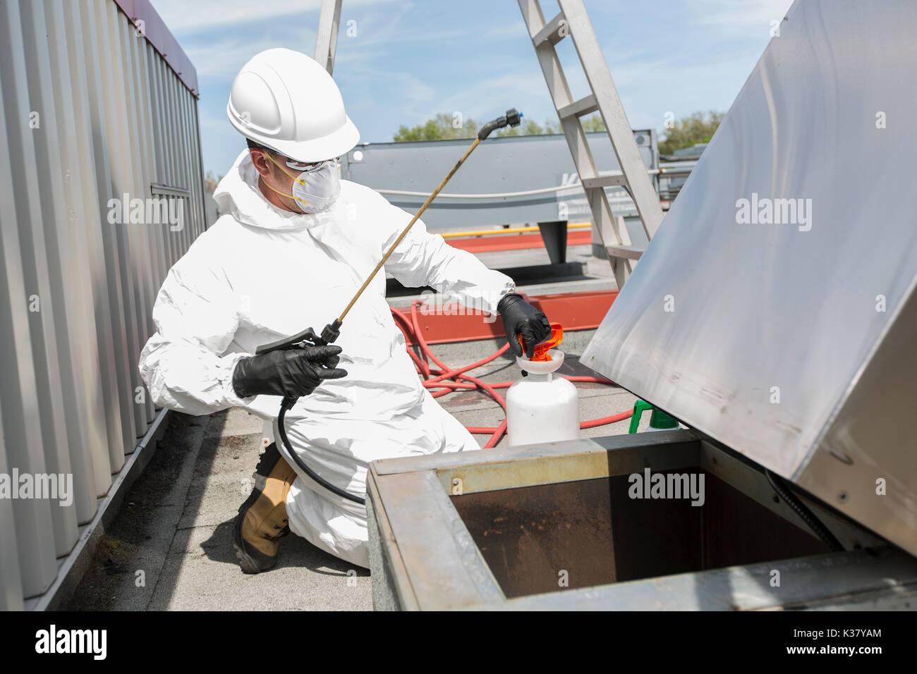 professional in protective uniform, mask, gloves in the roof for ...