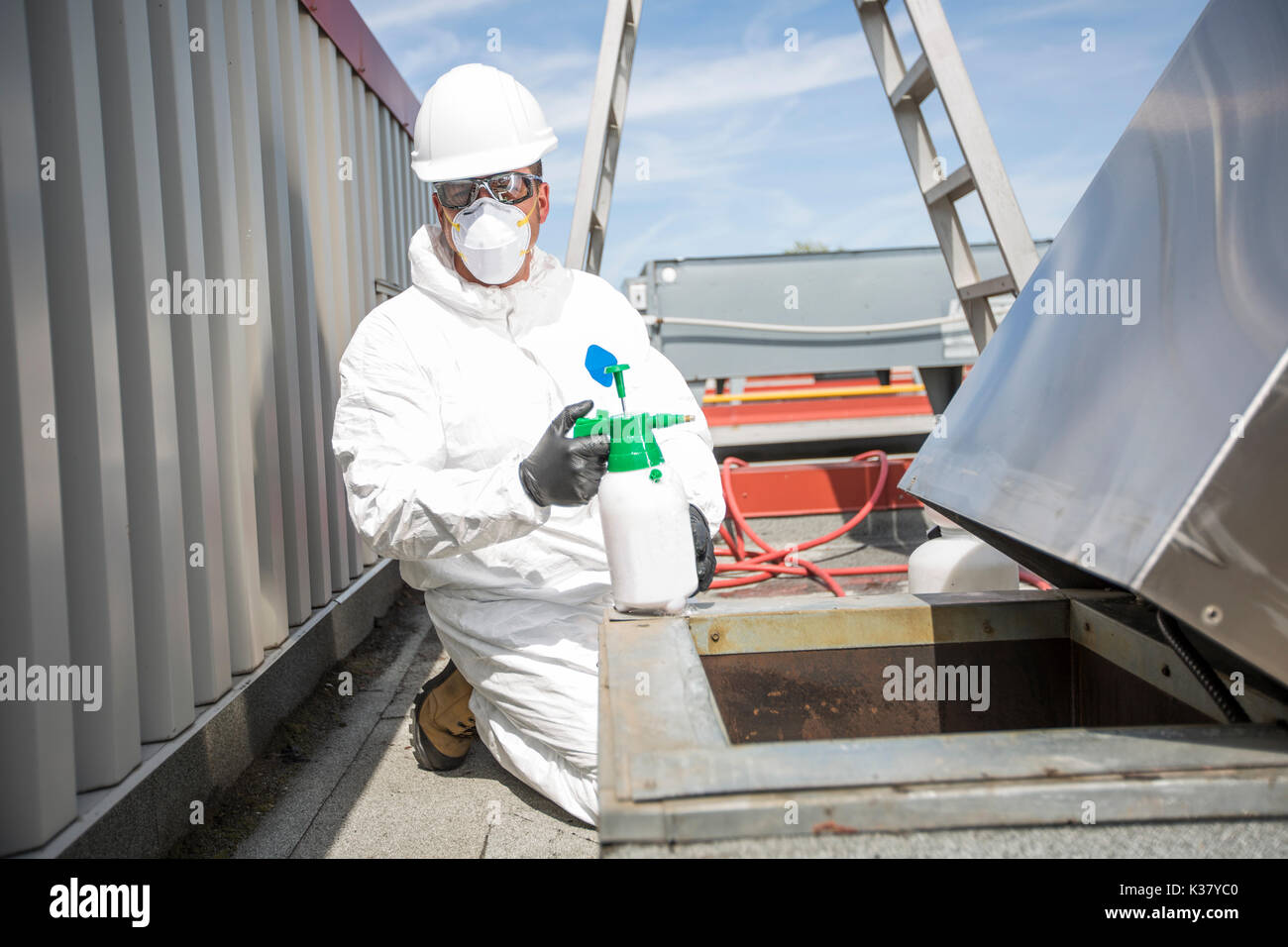 professional in protective uniform, mask, gloves in the roof for ...