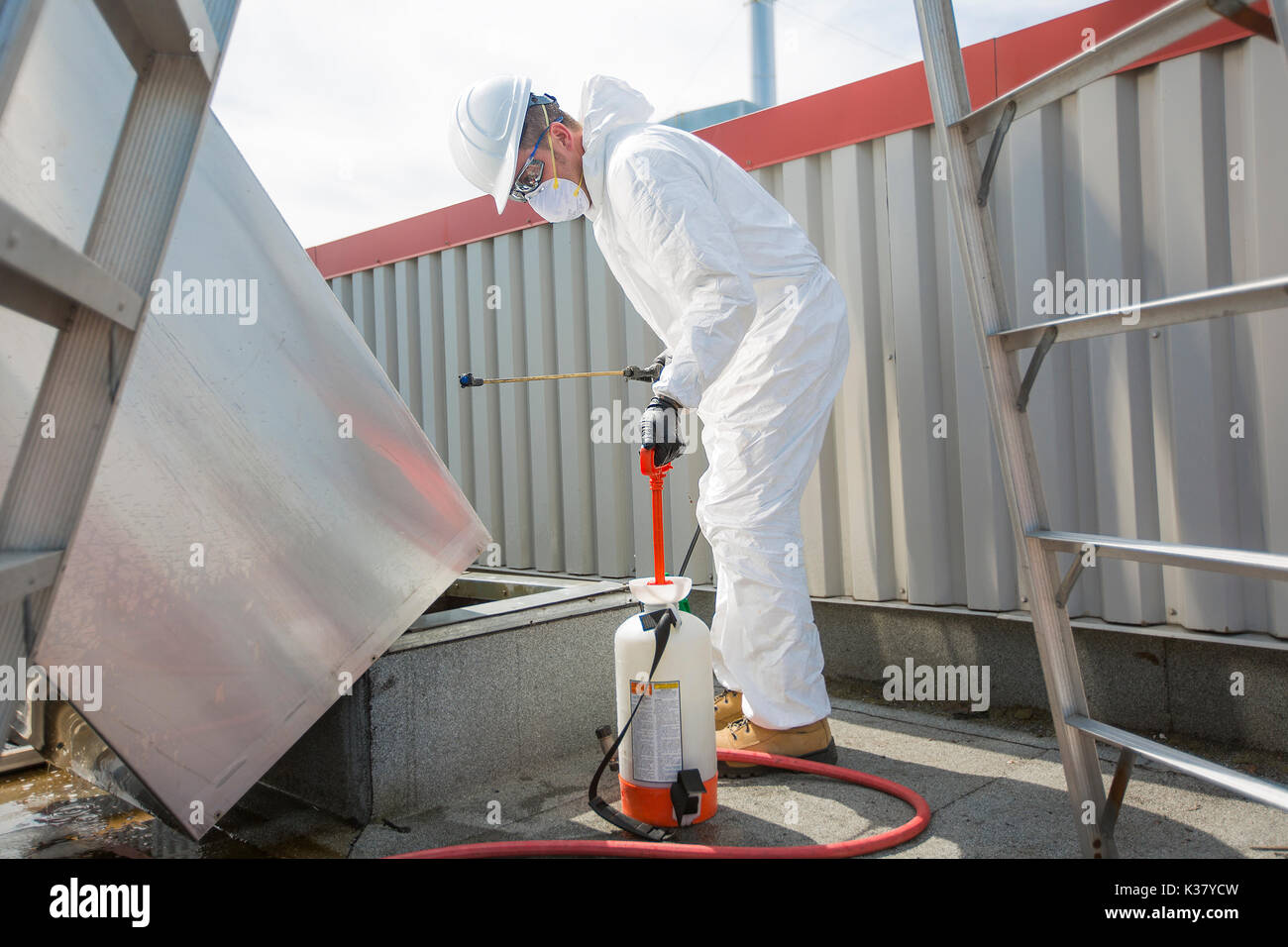professional in protective uniform, mask, gloves in the roof for ...