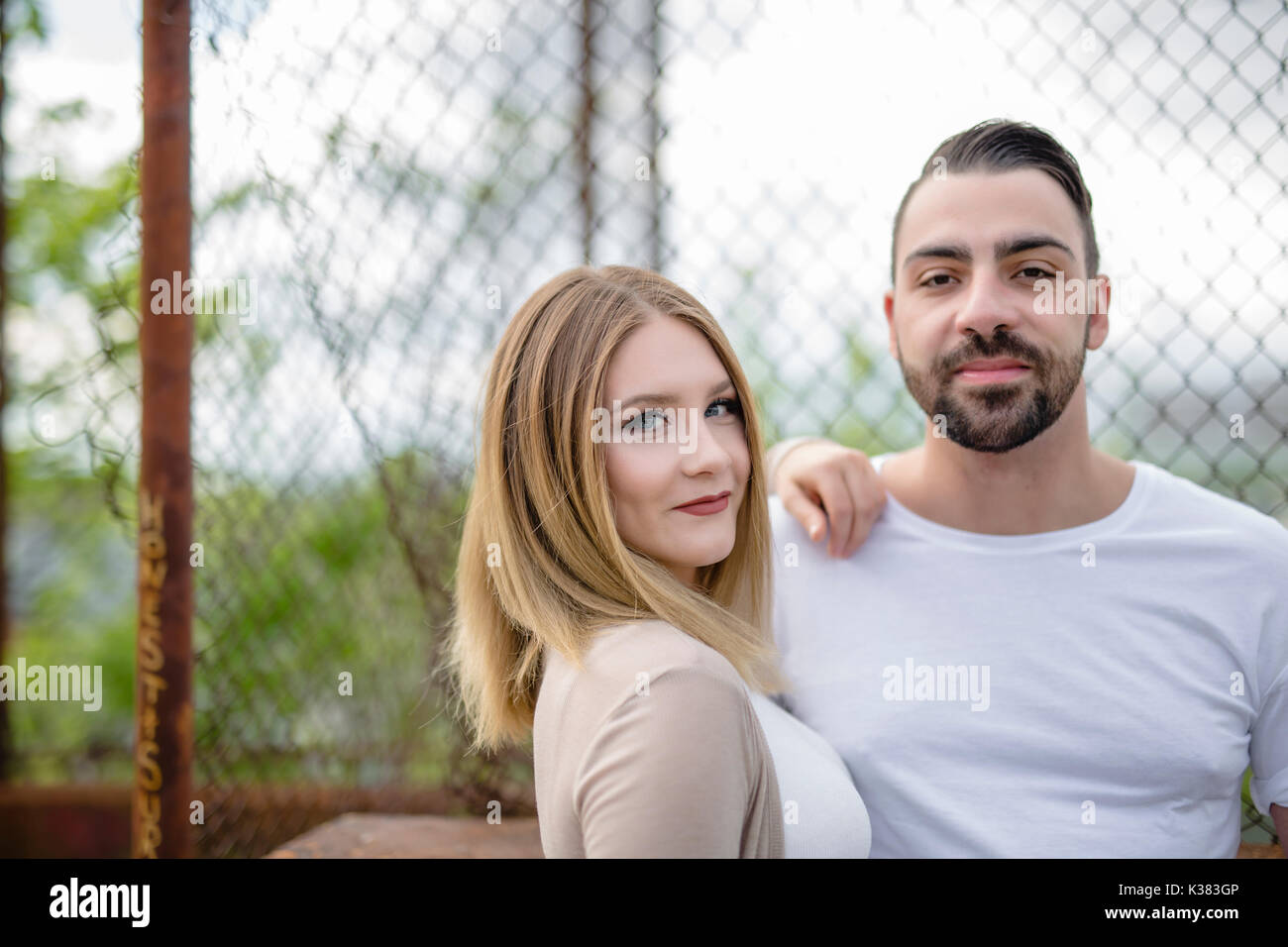 Couple close to a fence in a day Stock Photo - Alamy