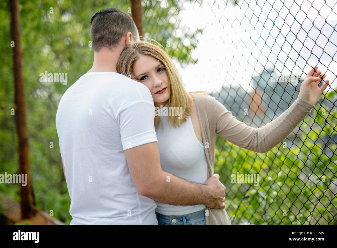 Couple close to a fence in a day Stock Photo - Alamy