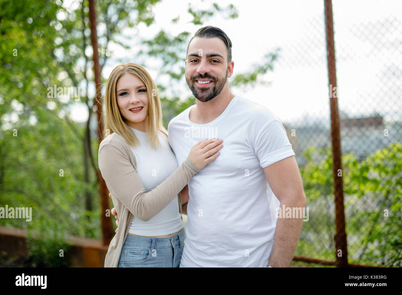 Couple close to a fence in a day Stock Photo - Alamy