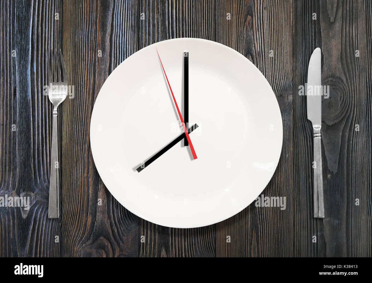 Conceptual idea. white plate with clock in the interior. Knife and fork ...