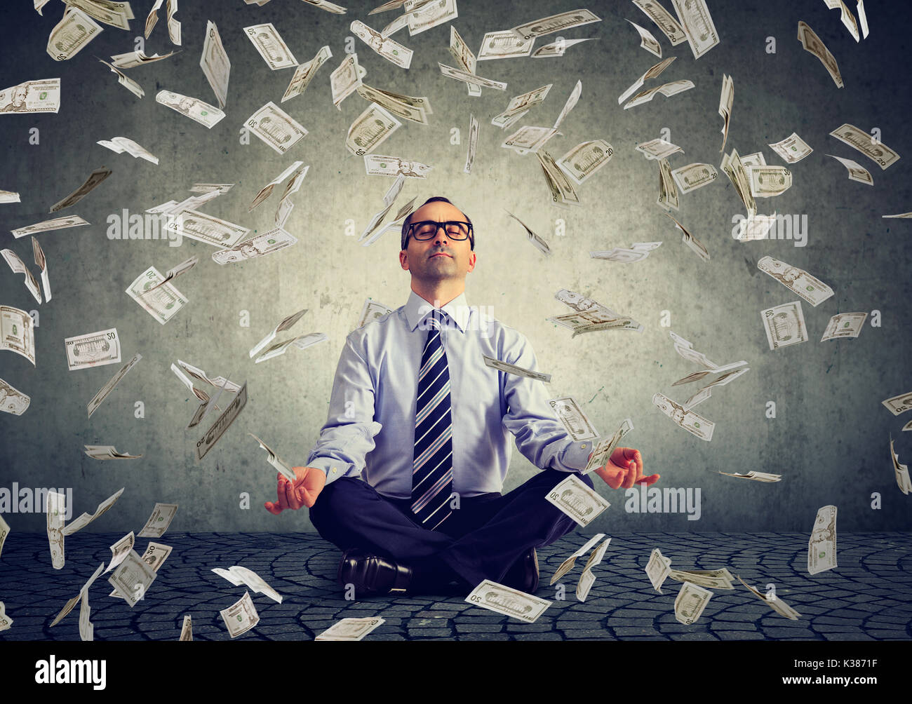 Business man meditating under money rain Stock Photo - Alamy