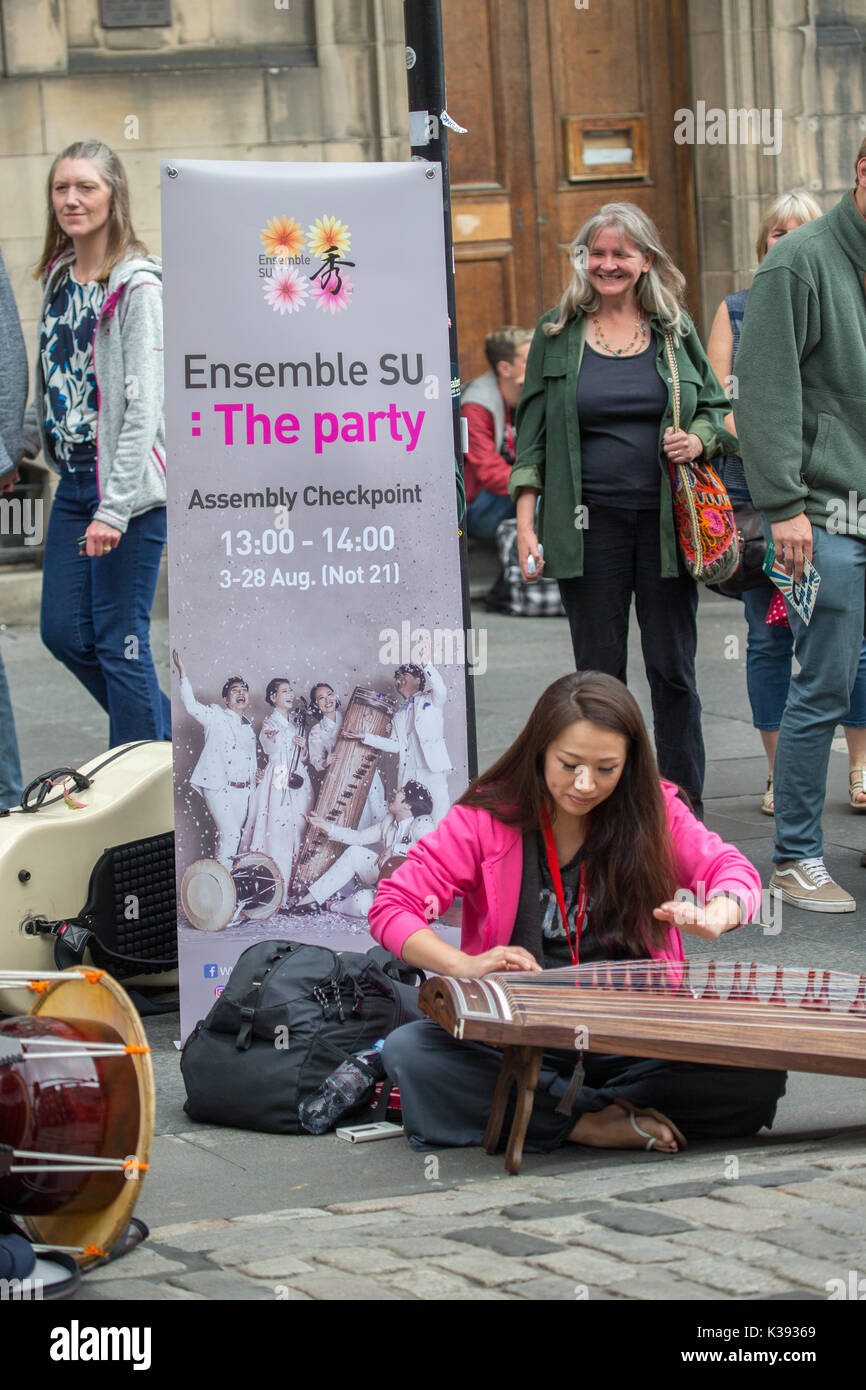 A young Korean musician playing a traditional stringed instrument at ...