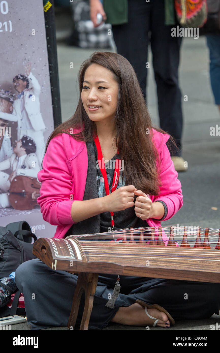 A young Korean musician playing a traditional stringed instrument at ...