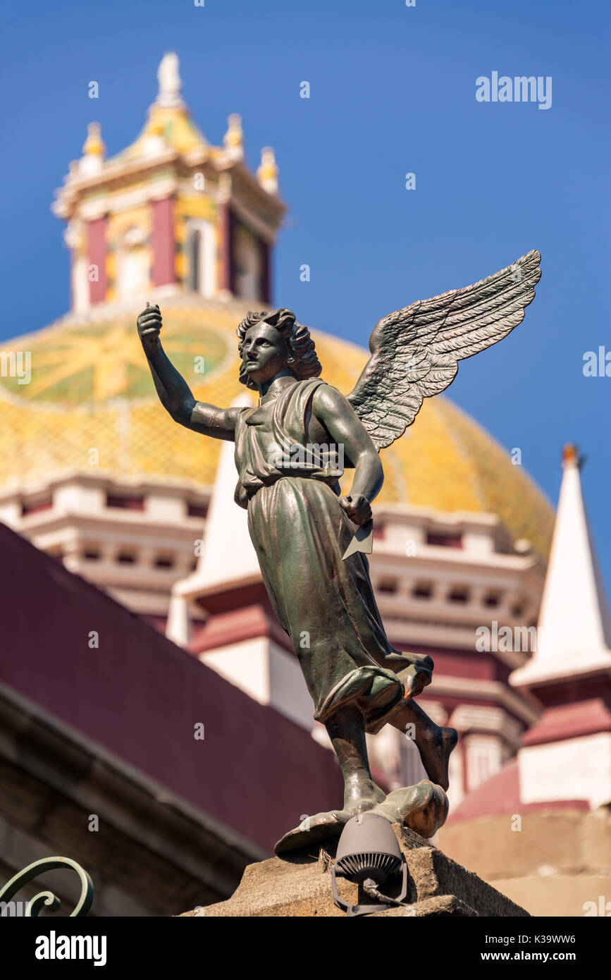 Small angel statue with the dome of the cathedral of Puebla, Mexico in ...