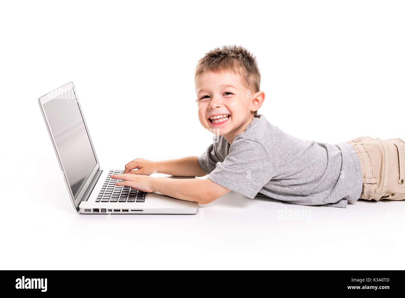 little kid with laptop lay on the ground Stock Photo - Alamy