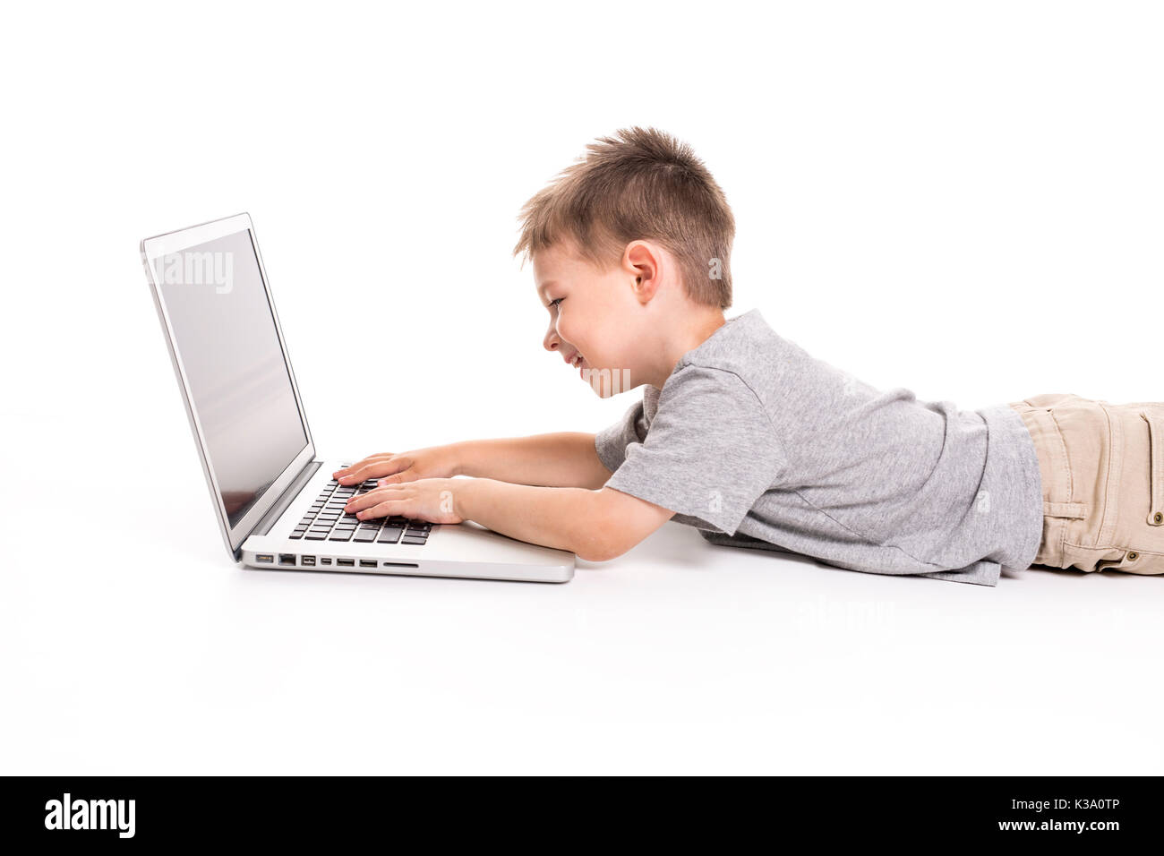 little kid with laptop lay on the ground Stock Photo - Alamy
