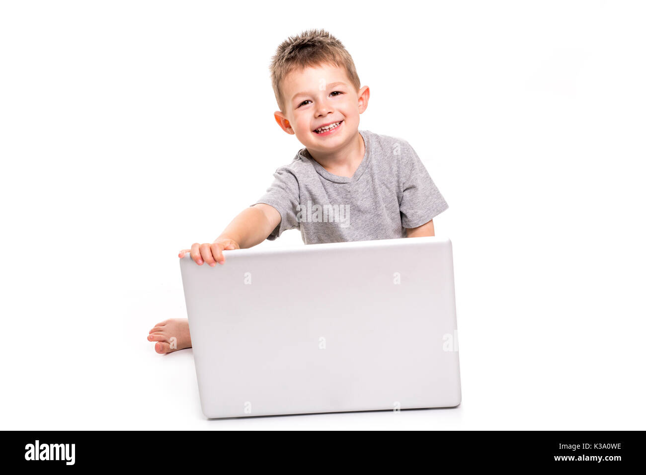little kid with laptop lay on the ground Stock Photo - Alamy