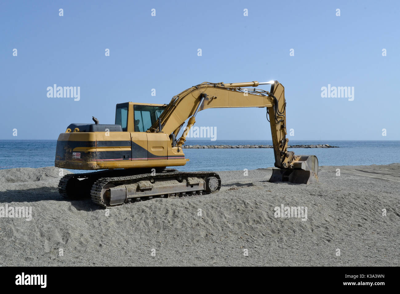 scraper excavator shading the beach by the sea Stock Photo - Alamy