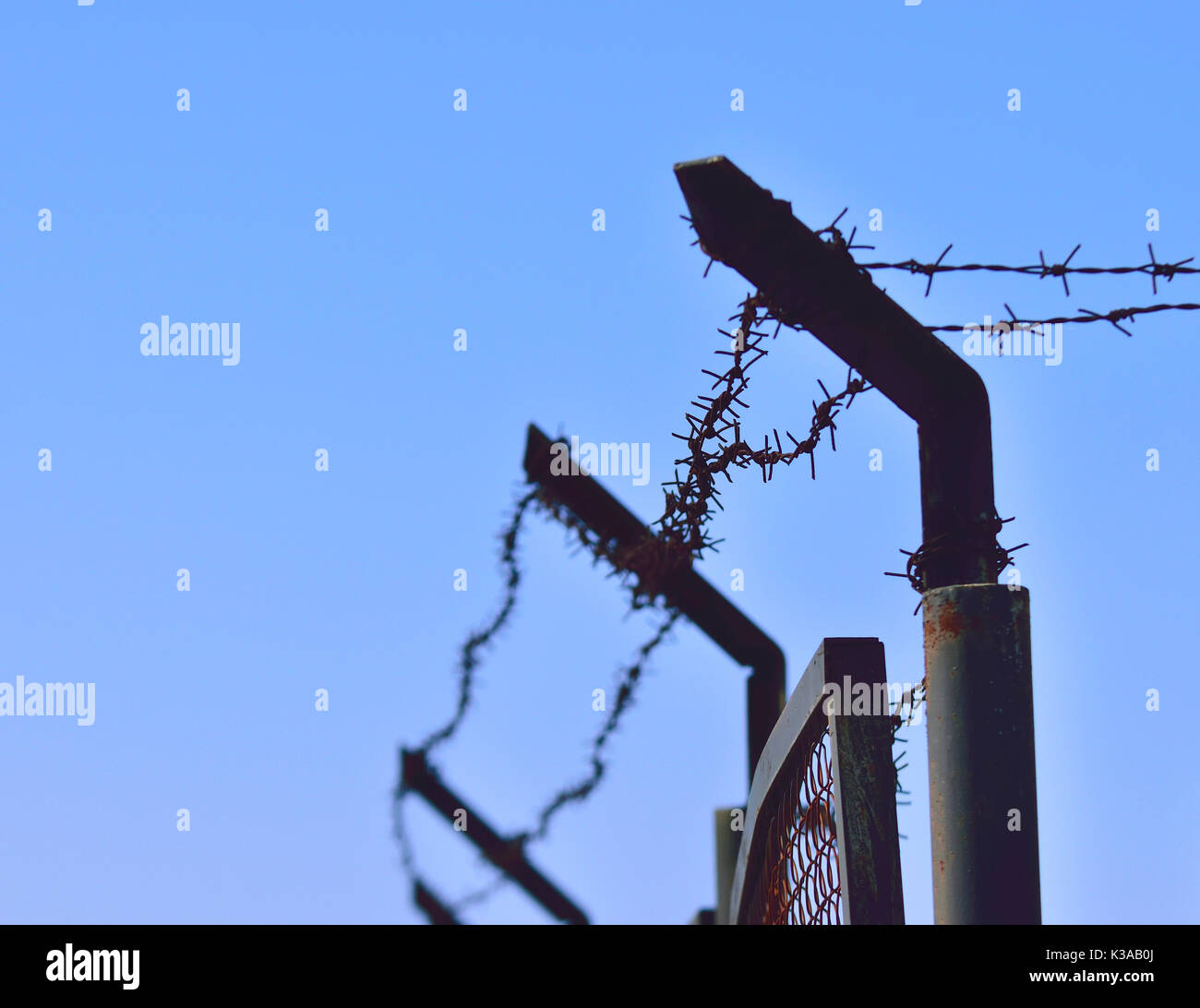 barbed wires On pillars against blue sky Stock Photo - Alamy