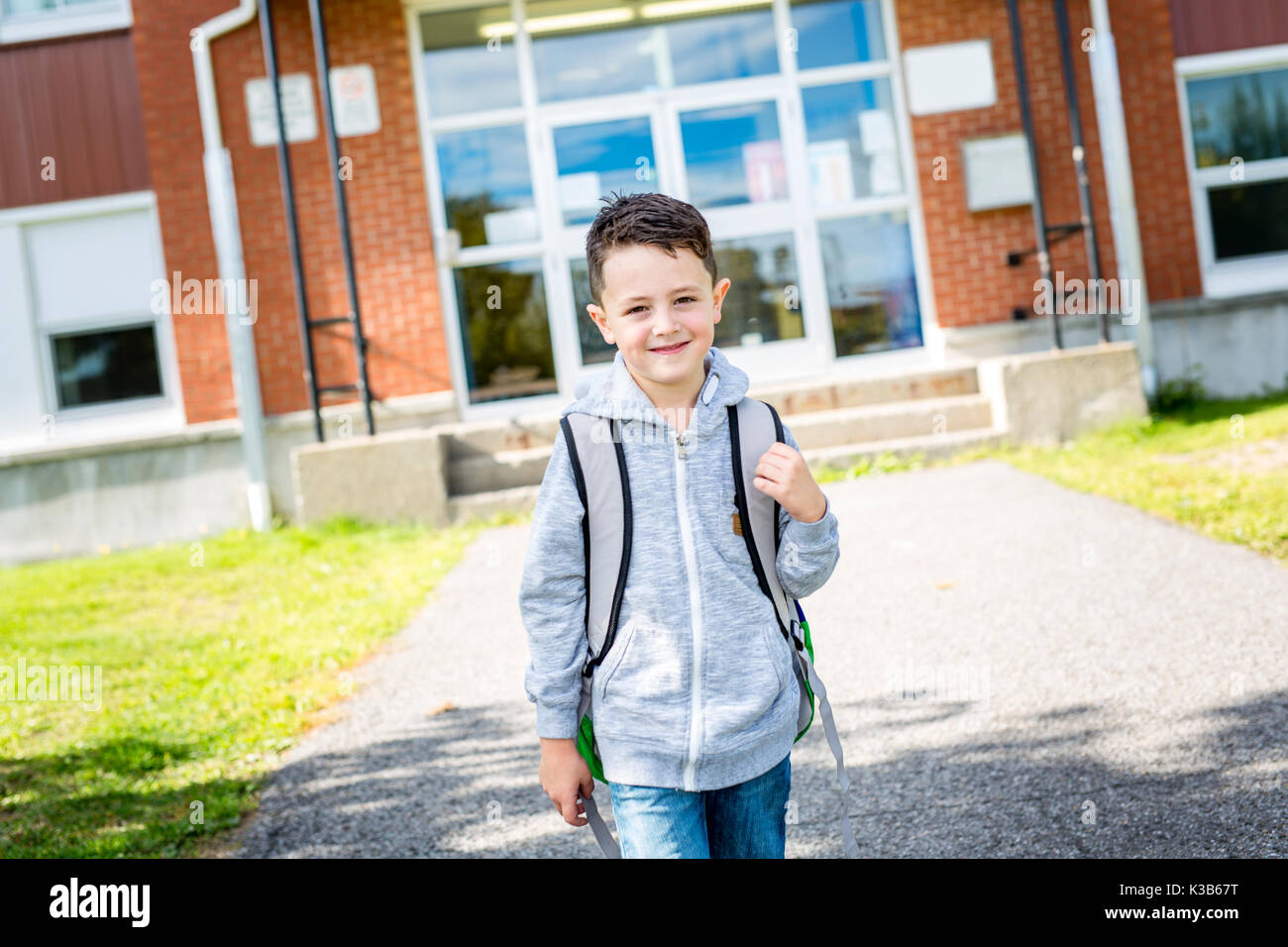 student outside school standing smiling Stock Photo - Alamy