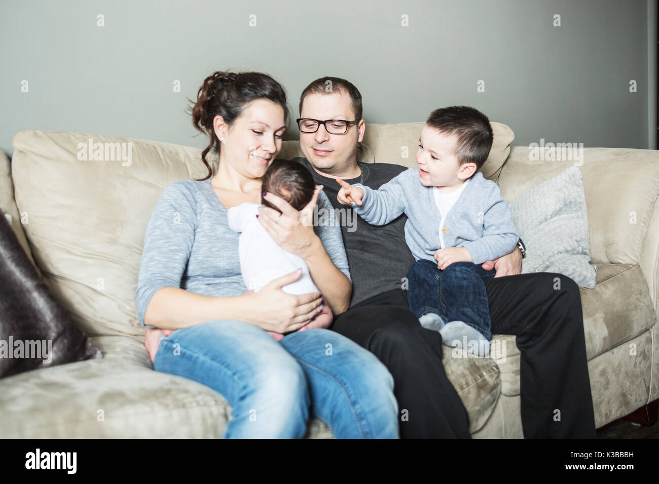 Young happy family with two children at home Stock Photo - Alamy