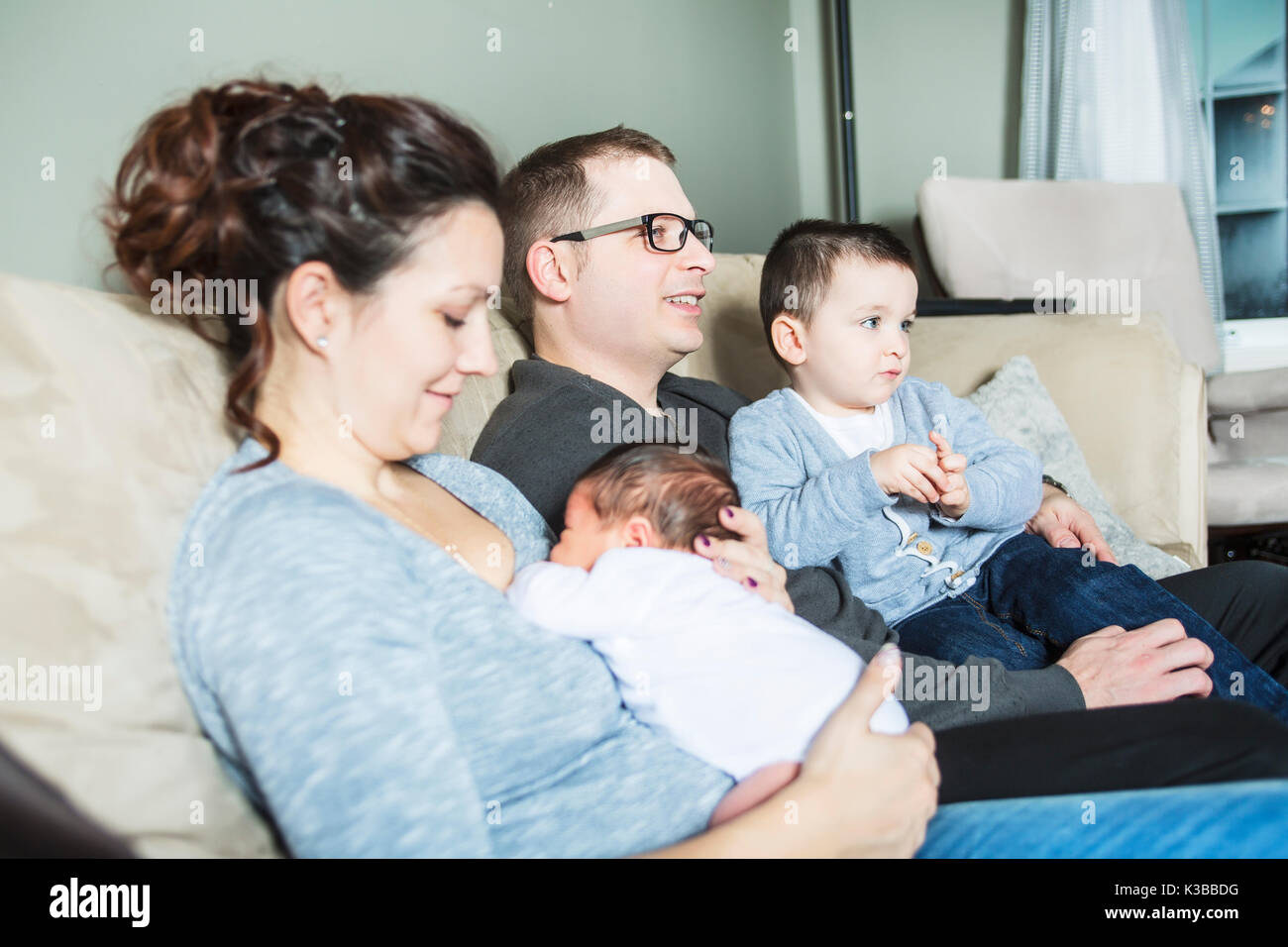 Young happy family with two children at home Stock Photo - Alamy