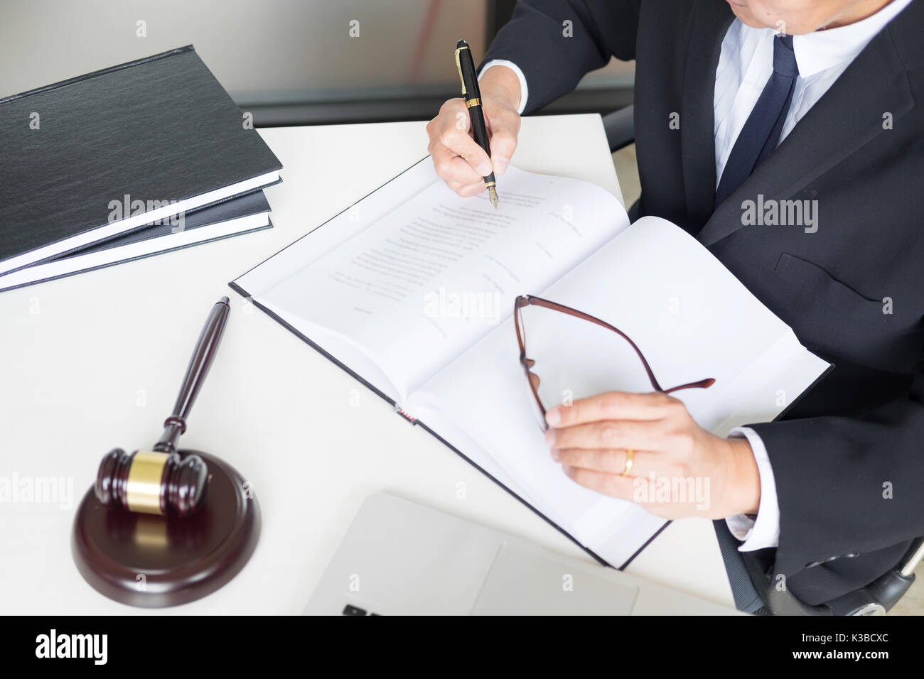 lawyer hand writes the document in court (justice, law) with sounding ...