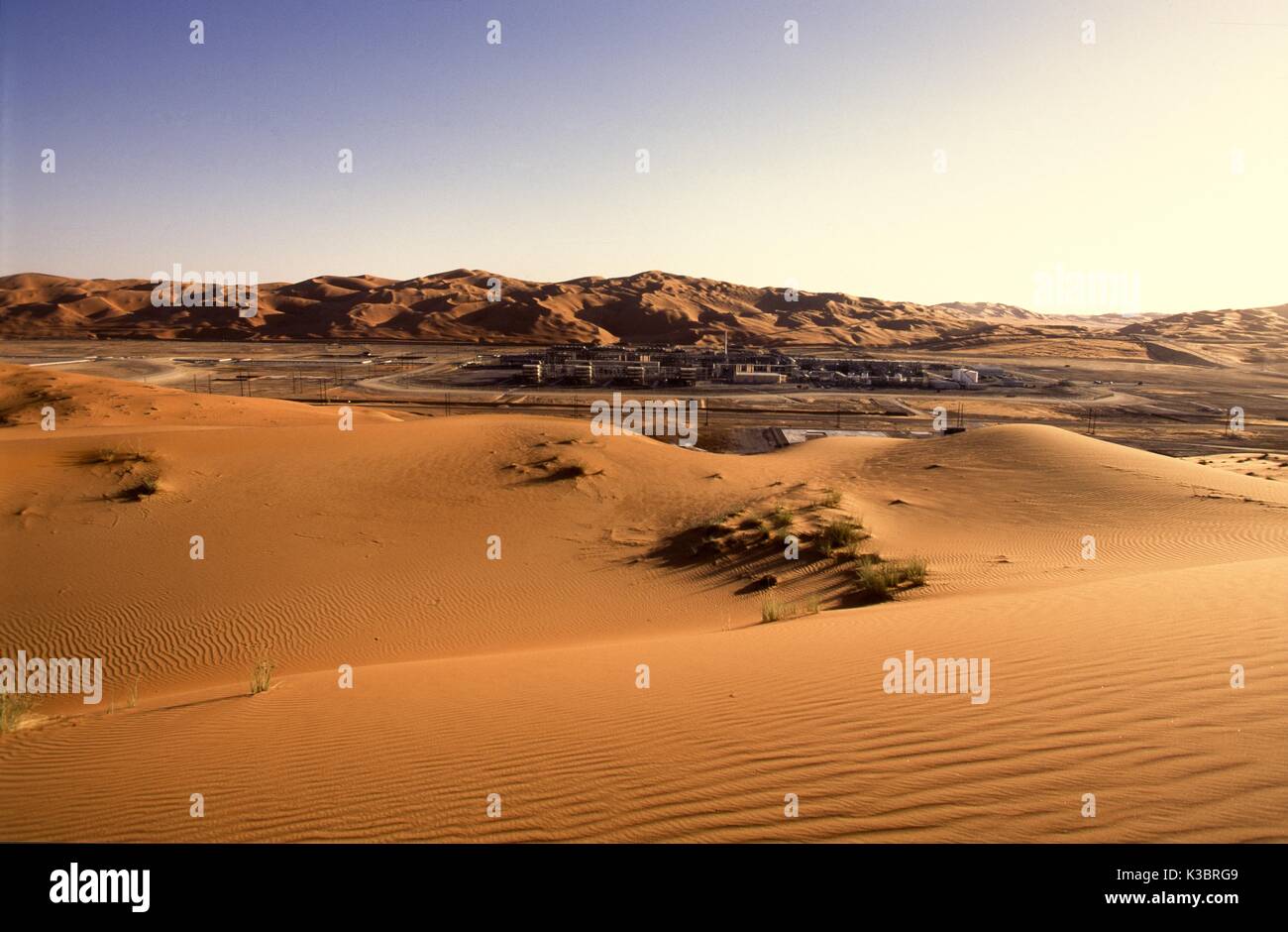 An oil rig searching for oil amongst the sand dunes that will feed into ...