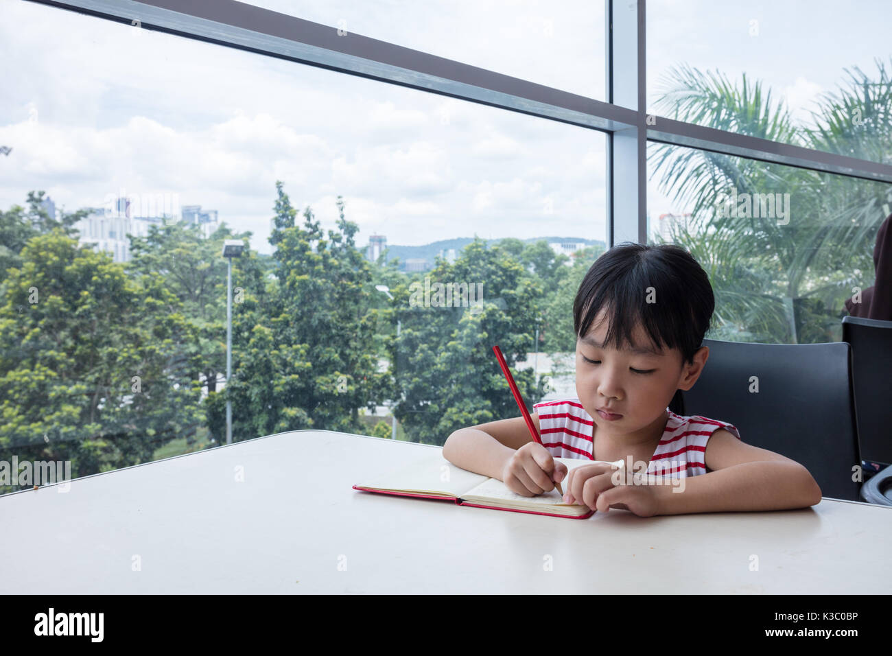 Asian little Chinese girl writing homework at home Stock Photo - Alamy