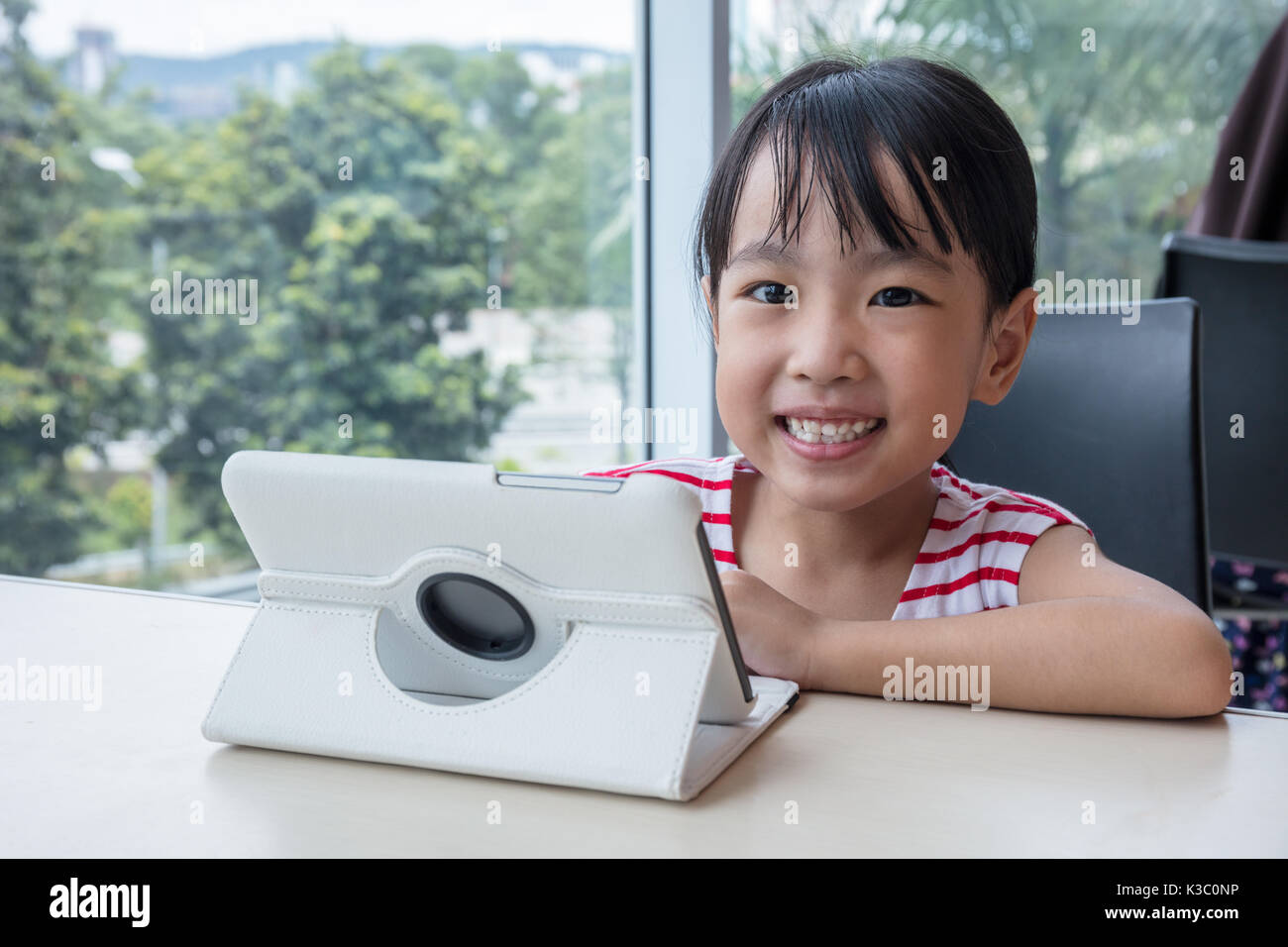 Asian Chinese little girl playing tablet computer at home Stock Photo ...