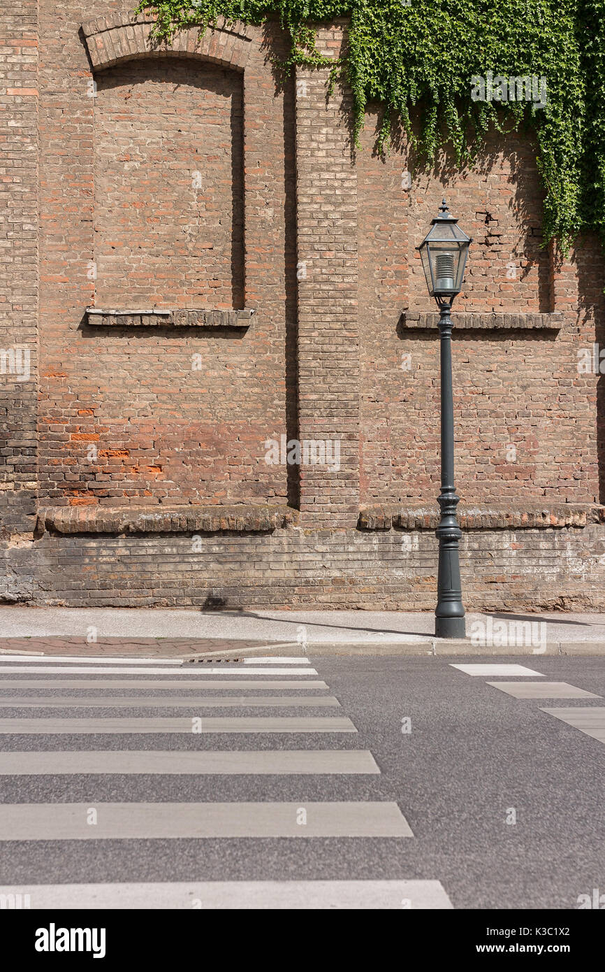 Old fashioned lamp post in front of old brick building, with bricked up ...