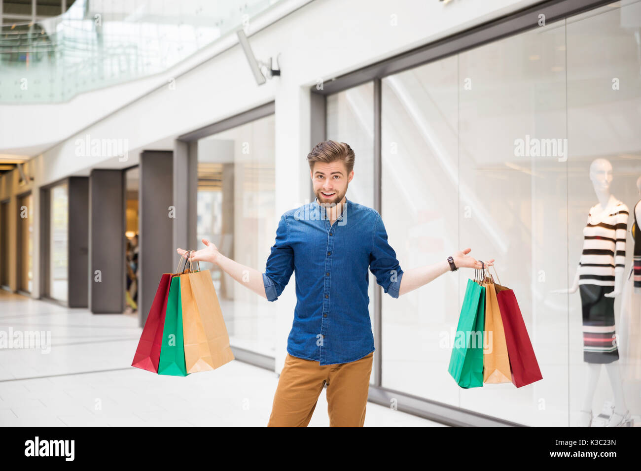 A photo of young man standing in the midle of the mall with shopping ...