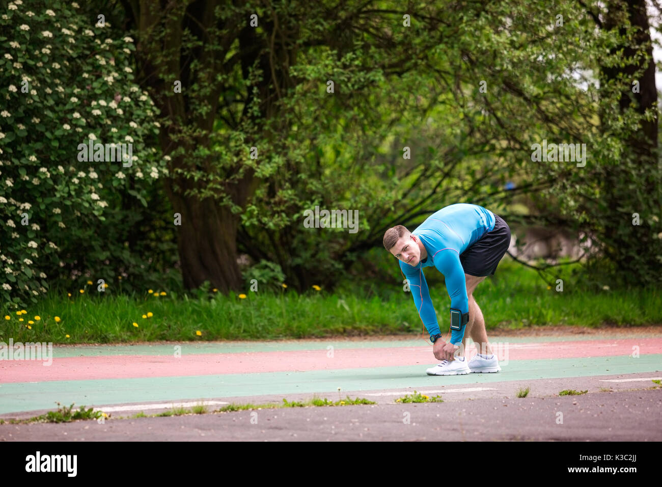 A photo of young, muscular man warming up during jogging Stock Photo ...