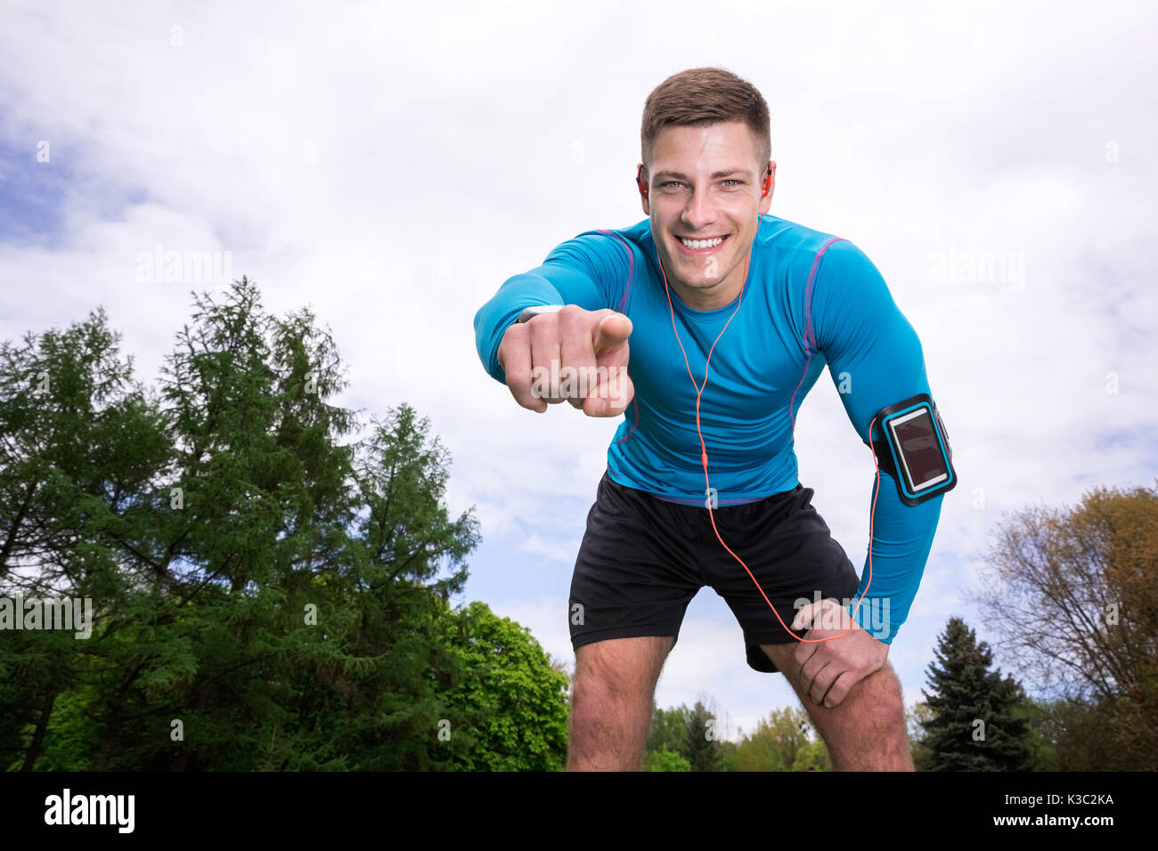 A photo of young, muscular man in sports wear pointing at the camera ...