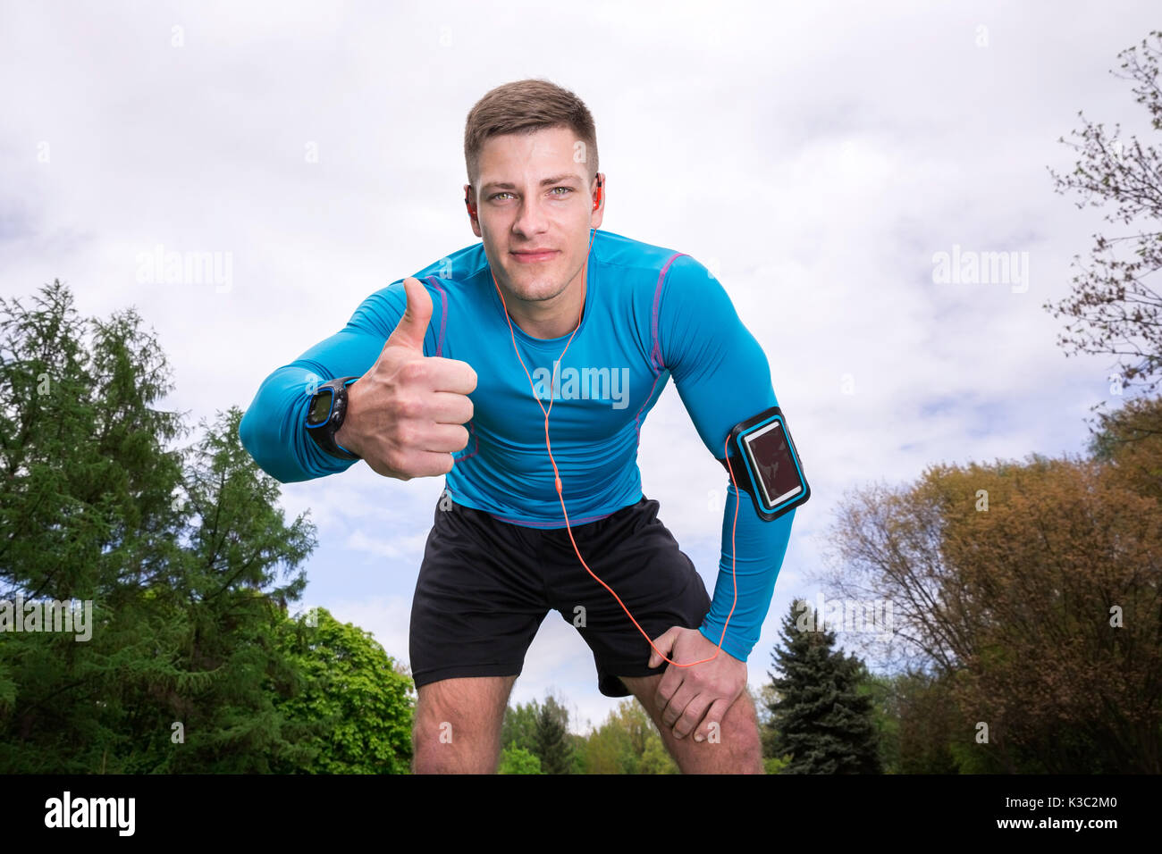 A photo of young, musculate man in sports wear showing his thumb up ...