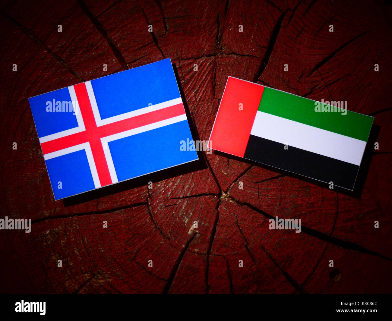 Icelandic flag with United Arab Emirates flag on a tree stump isolated ...