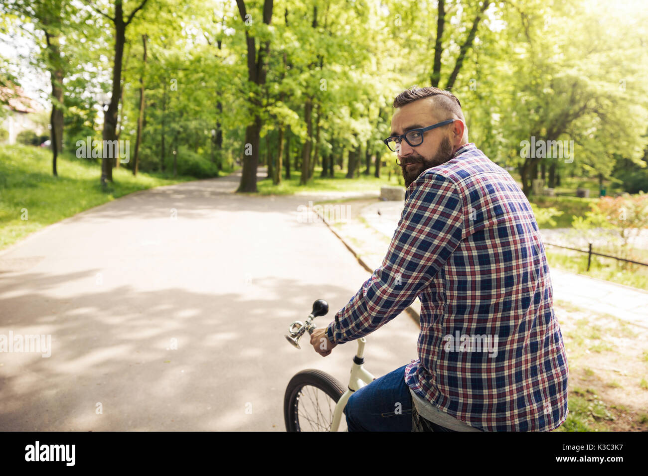 Portrait of young modern man turning back on bicycle Stock Photo - Alamy