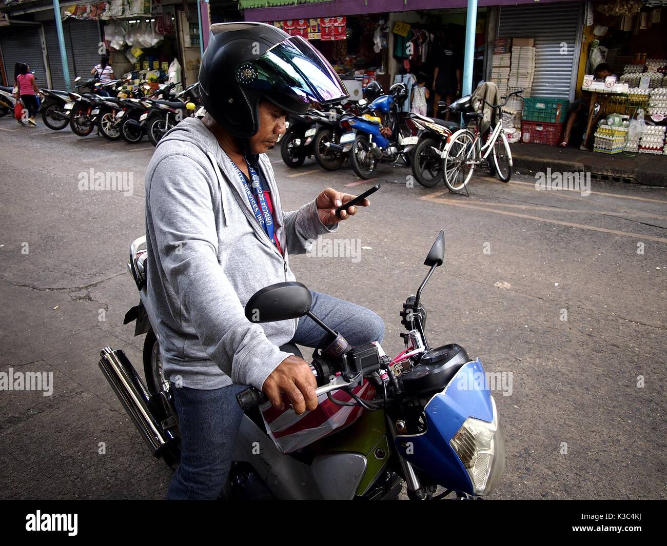 MARIKINA CITY, PHILIPPINES - AUGUST 28, 2017: A motorcycle rider stops ...