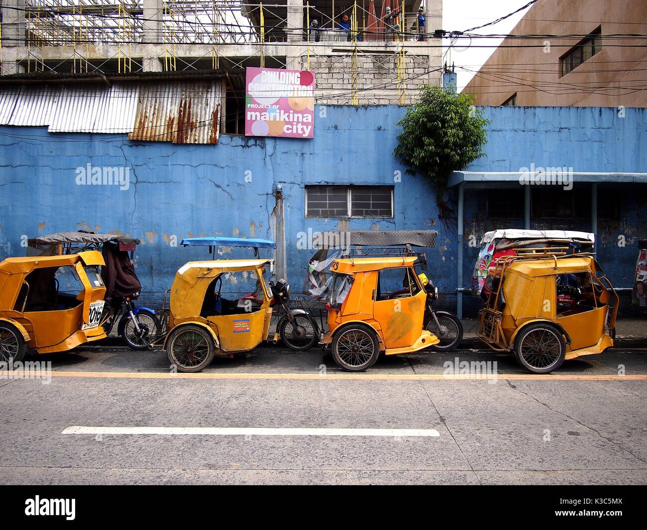 MARIKINA CITY, PHILIPPINES - AUGUST 28, 2017: Yellow colored tricycles ...
