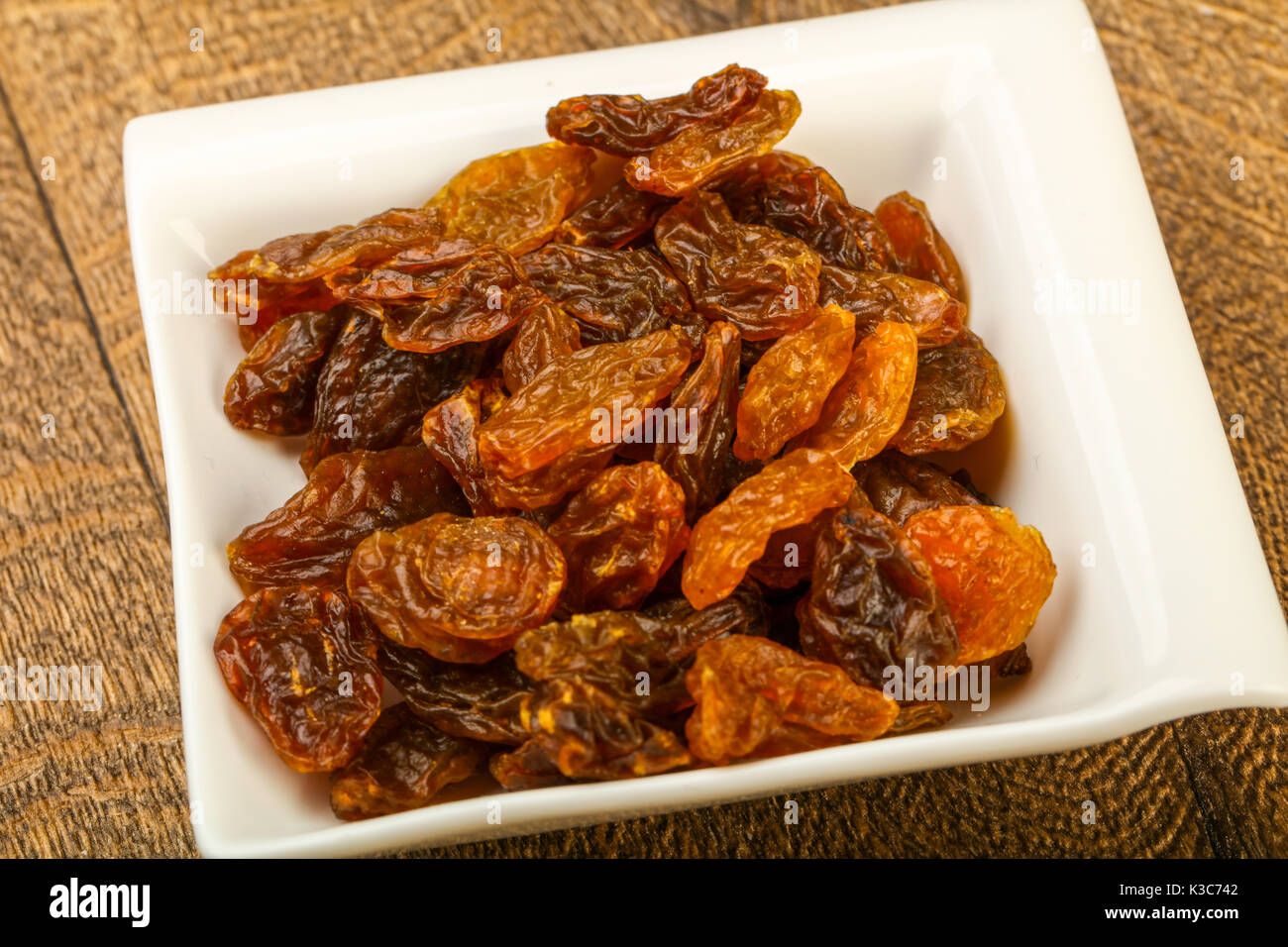 Dry Raisin in the bowl over the wooden background Stock Photo - Alamy
