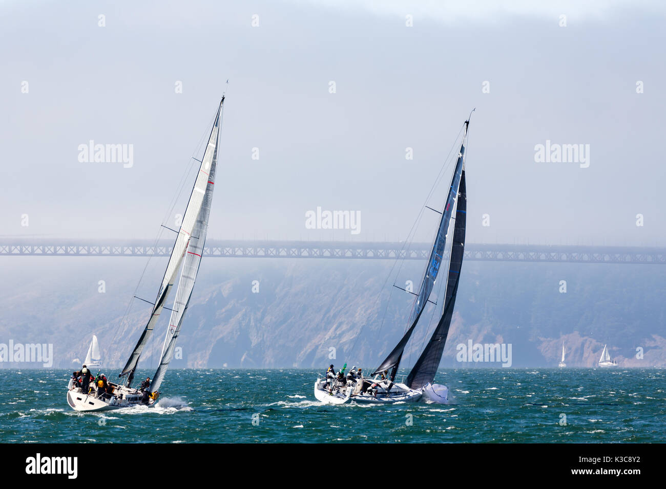 Two sailboats compete for the wind as they move forward near each other ...