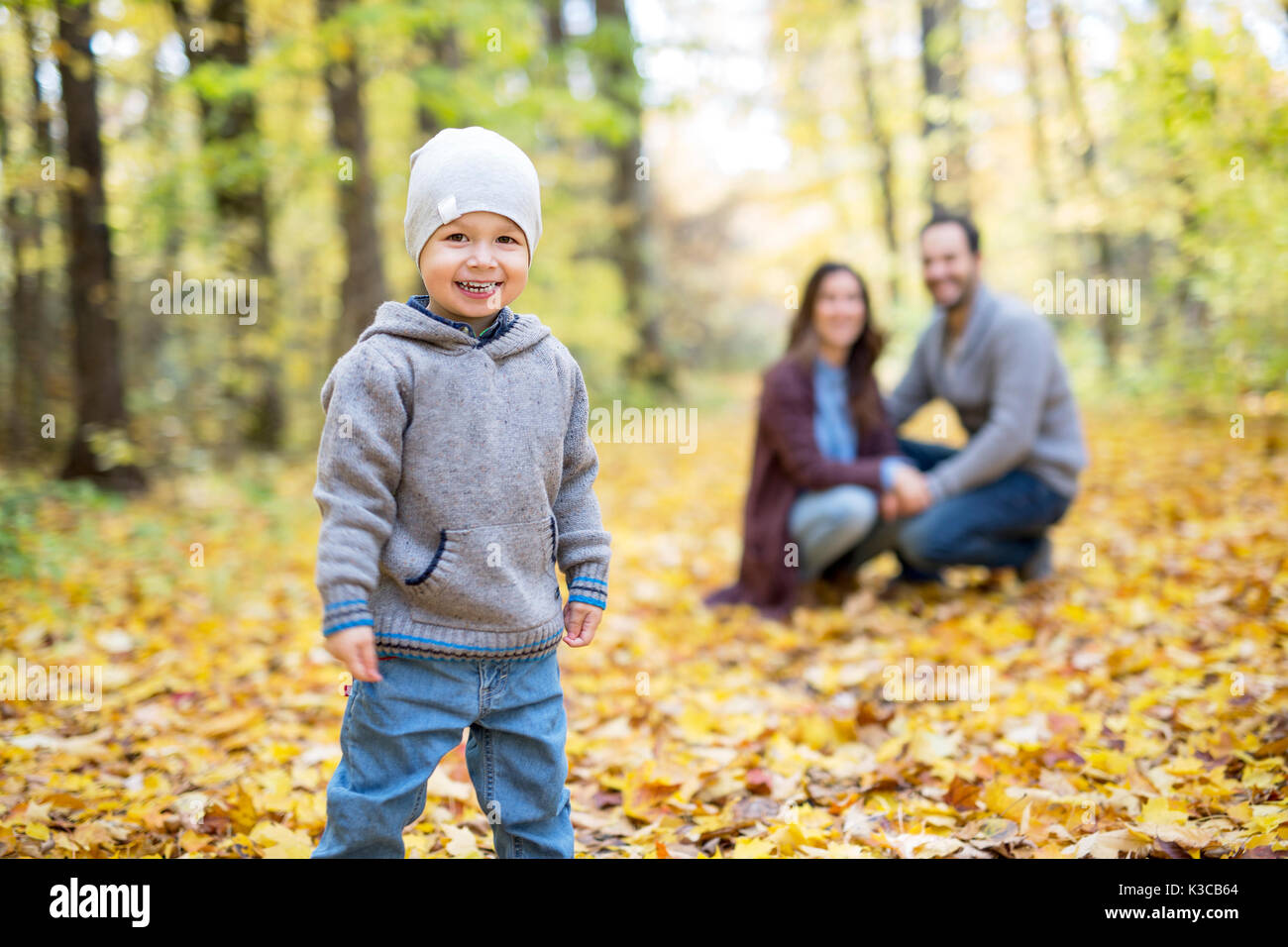 Happy family relaxing outdoors In autumn park Stock Photo - Alamy