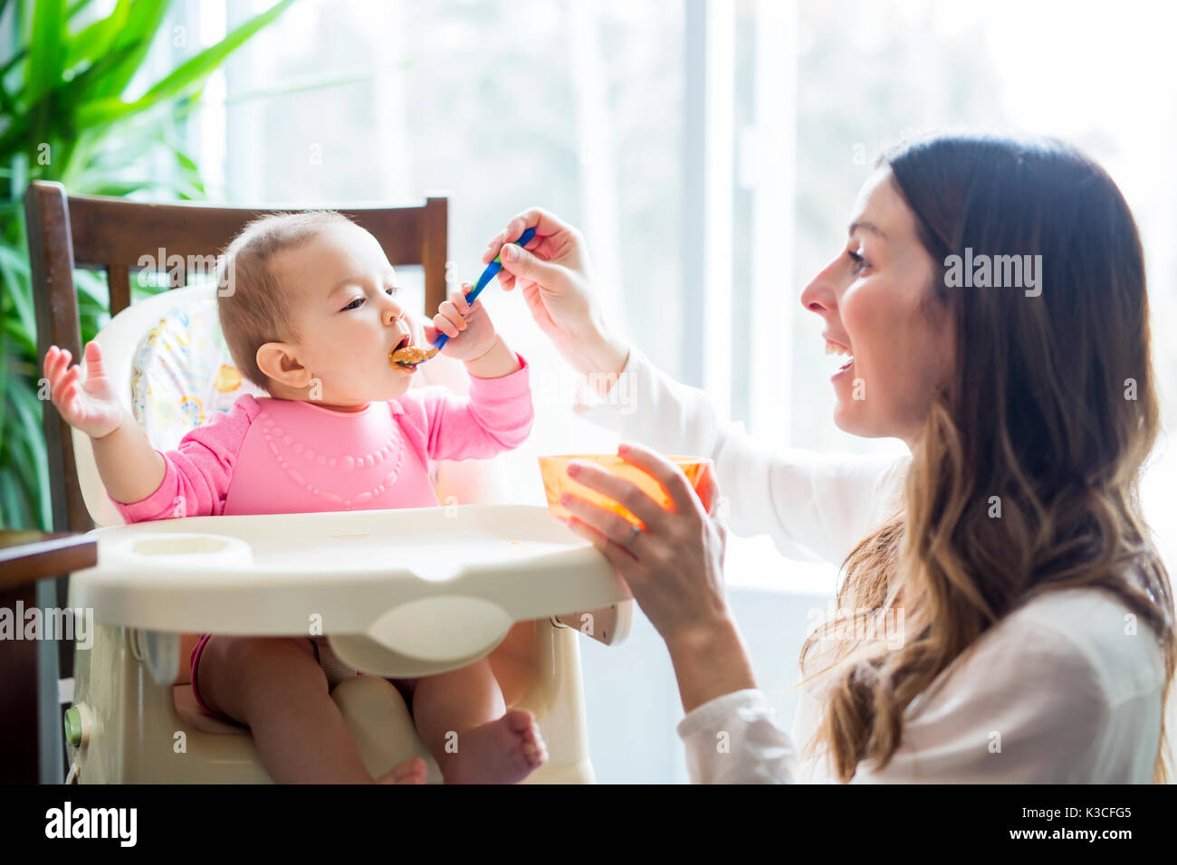 Mother feeding baby with spoon Stock Photo - Alamy