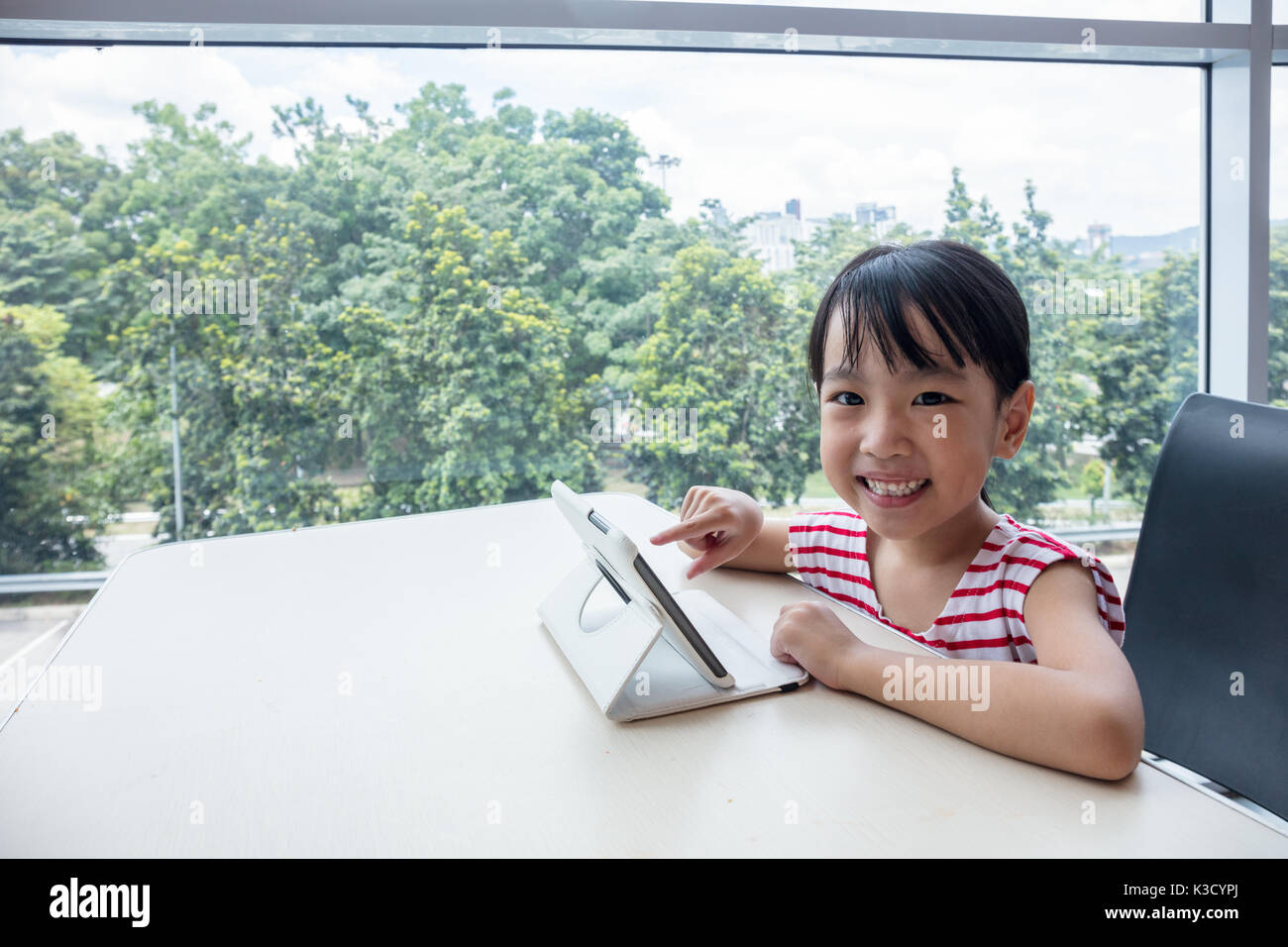Asian Chinese little girl playing tablet computer at home Stock Photo ...
