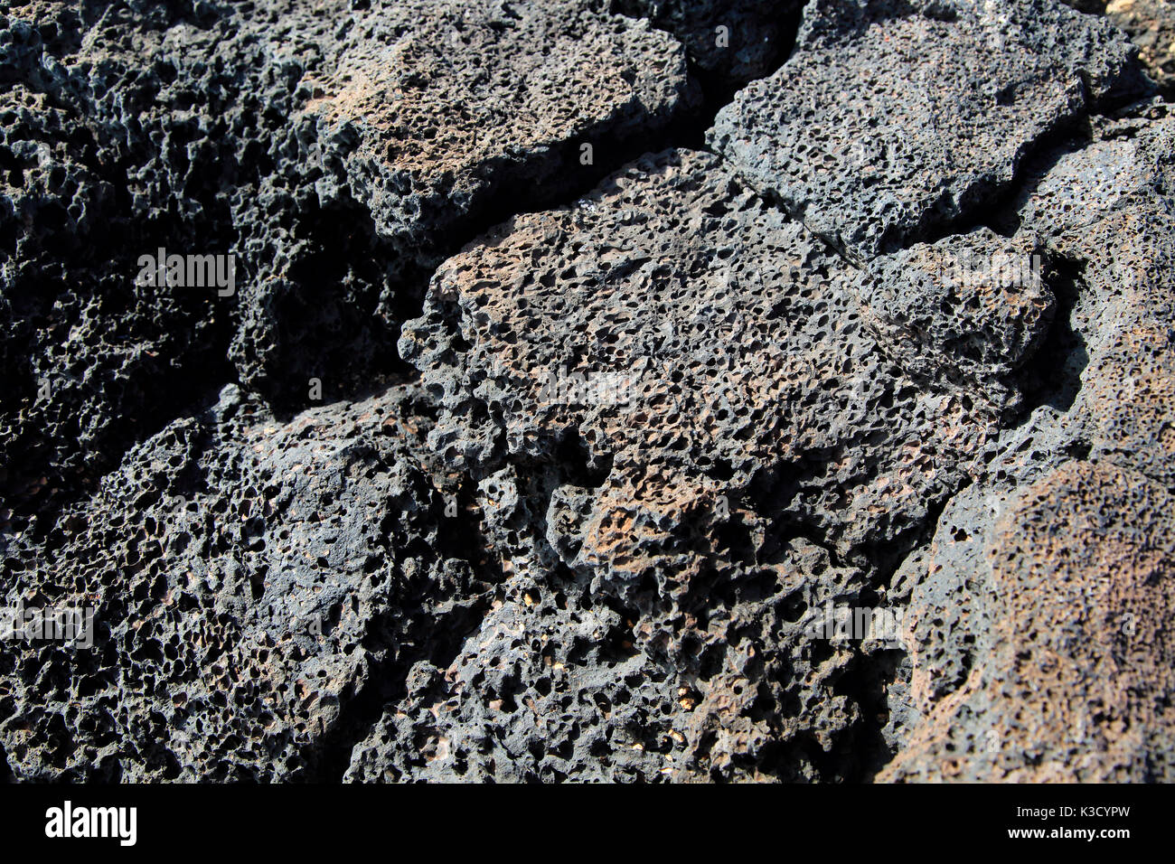 Close up of air holes in rock formed from volcanic lava flow ...